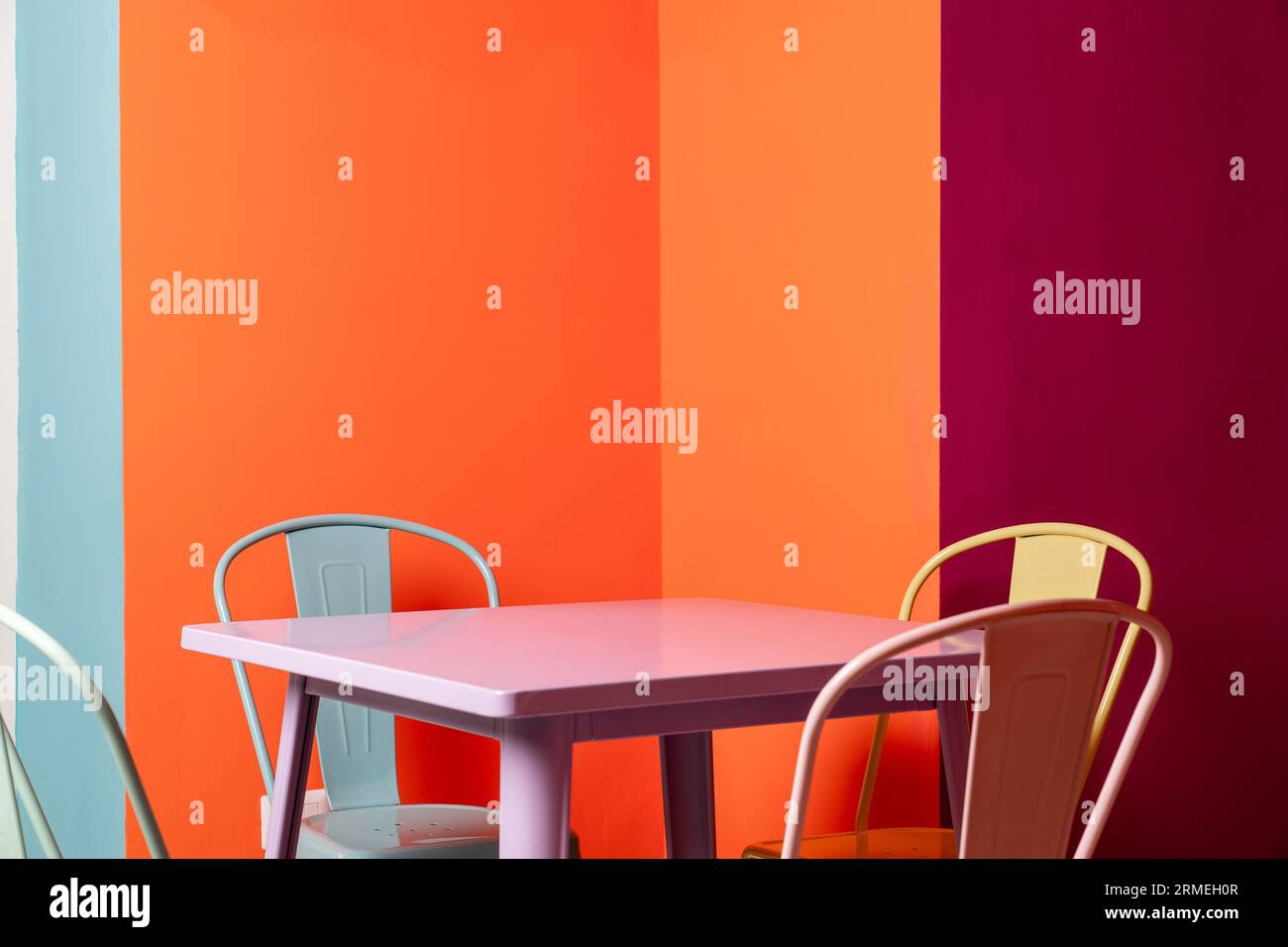 pink fast food restaurant table with yellow, blue colored chairs and an ...