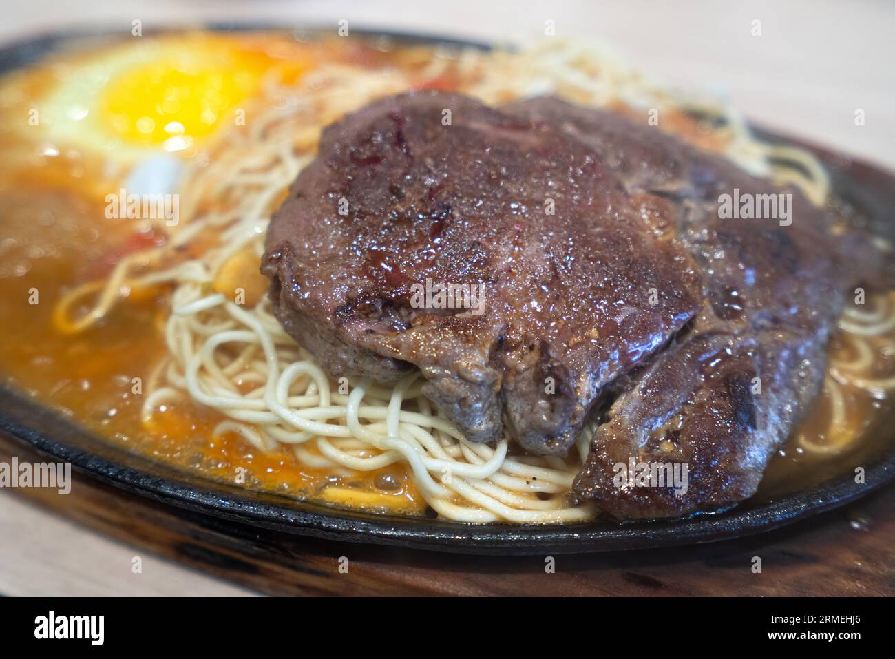 Taiwanese style special sizzling beef steak with noodles, egg and sauce ...