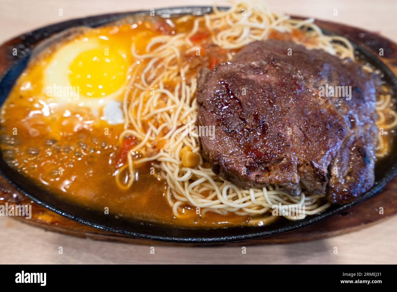 Taiwanese style special sizzling beef steak with noodles, egg and sauce ...
