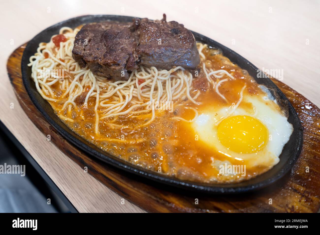 Taiwanese style special sizzling beef steak with noodles, egg and sauce ...