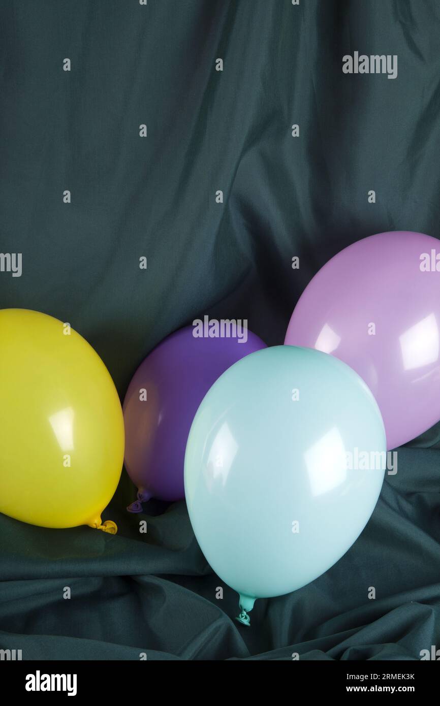 balloons in harmonious colors on a wavy green background. Minimal color ...