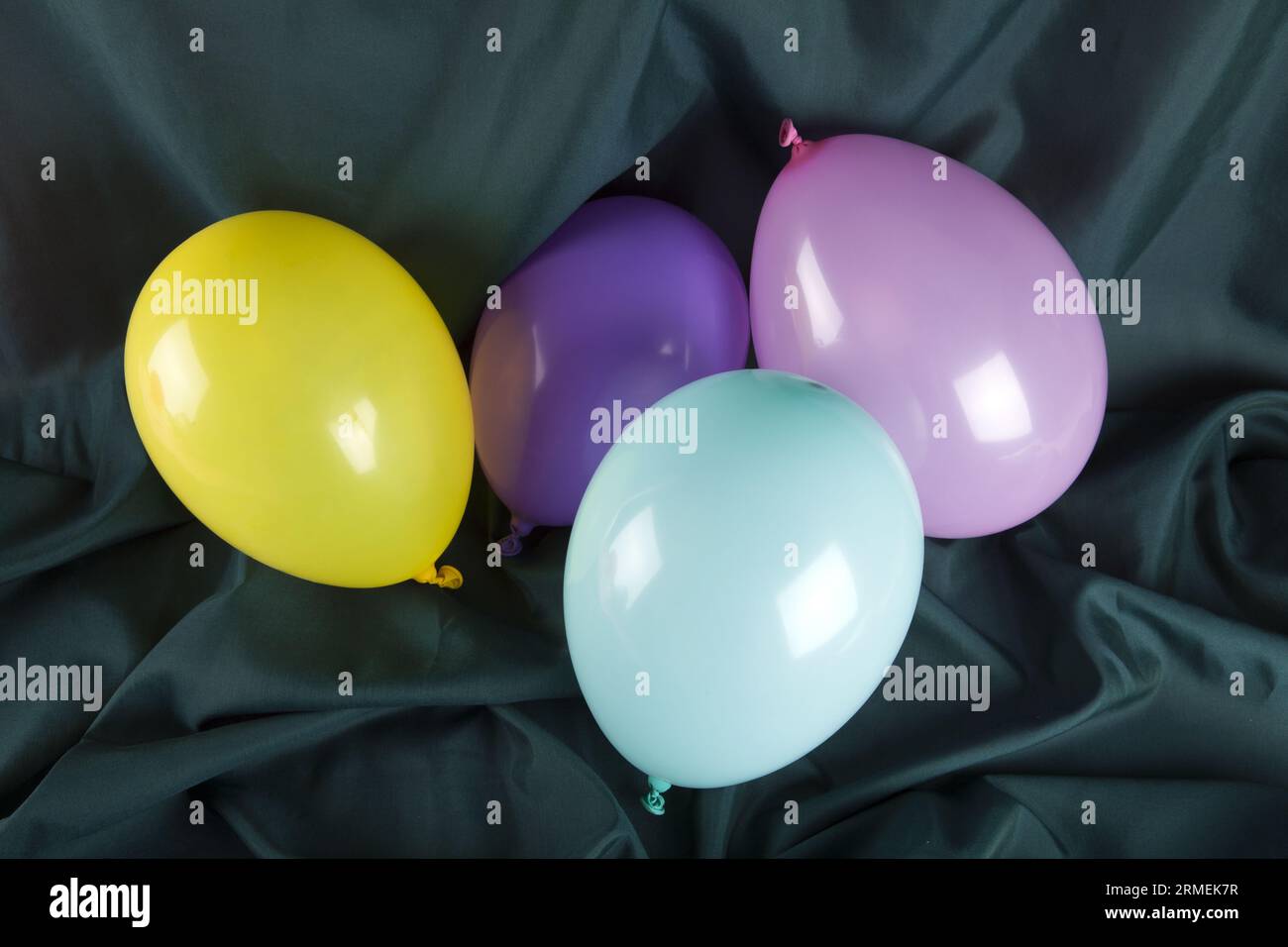 balloons in harmonious colors on a wavy green background. Minimal color ...