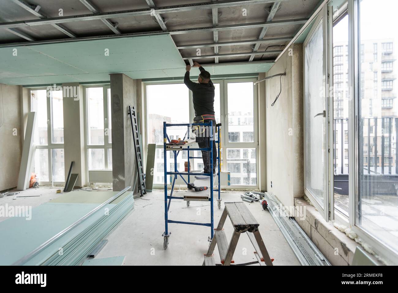 Construction worker installation ceiling work Stock Photo - Alamy