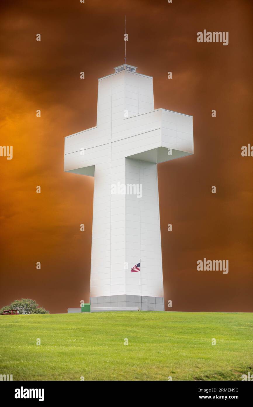 The Bald Knob Cross of Peace, situated in a lush green meadow against a ...