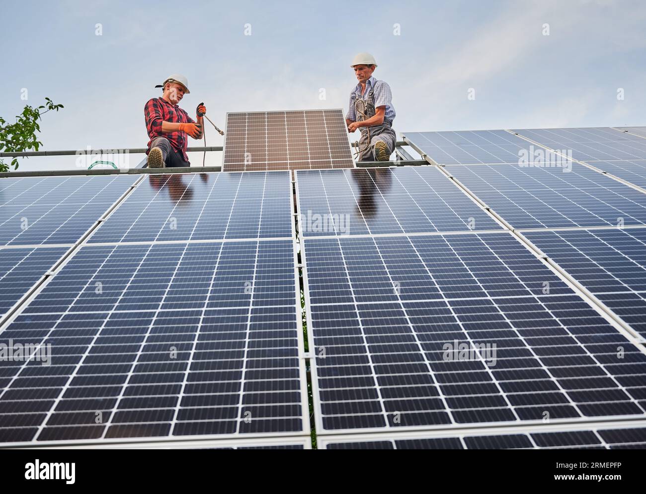 Male workers mounting photovoltaic solar panel system outdoors. Men ...