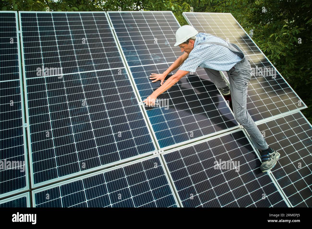 Male worker in safety helmet installing photovoltaic solar panels. Man ...