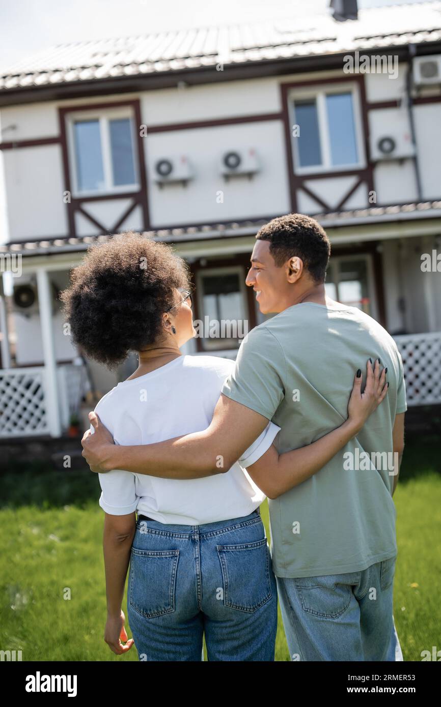 Smiling African American Man Hugging Girlfriend And Talking Near New
