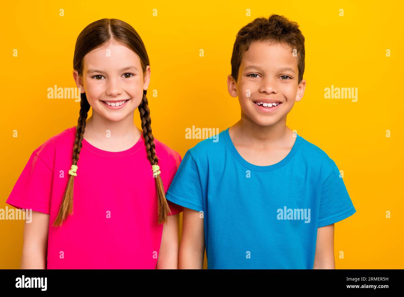 Photo of sweet cheerful preteen schoolchildren wear t-shirts smiling ...