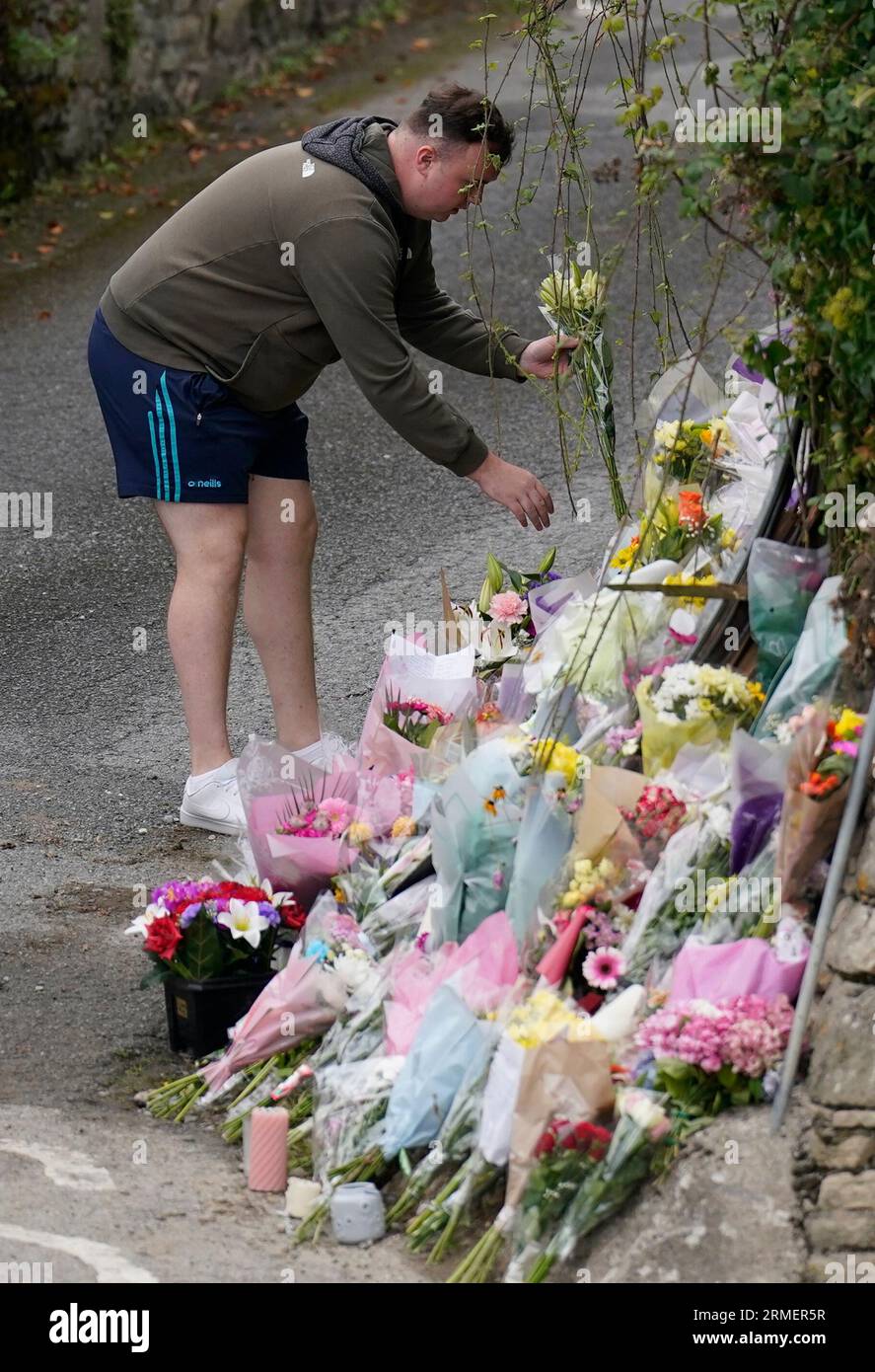 A man lays a floral tribute at the scene of a crash, in memory of Luke ...