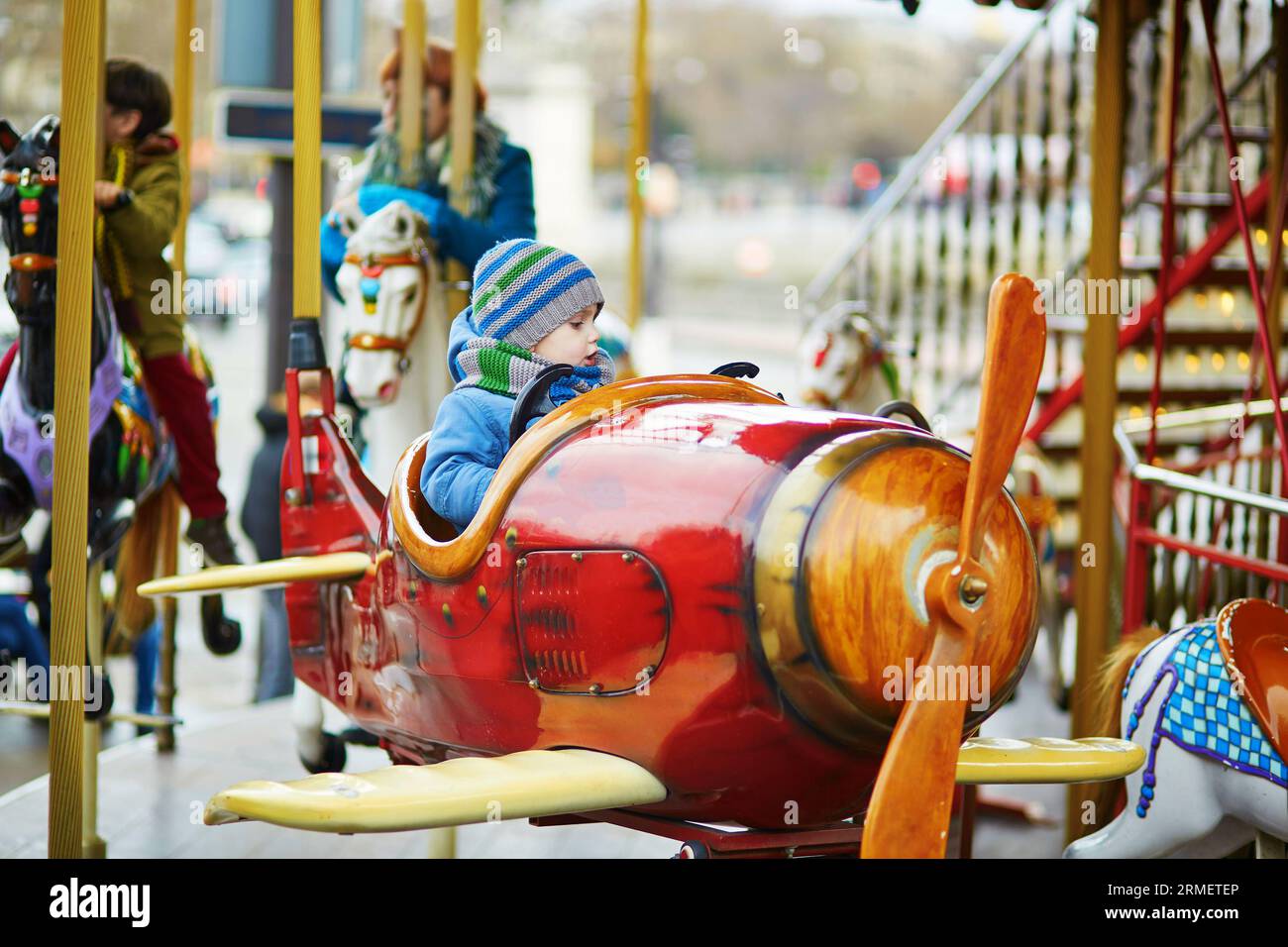 Cute little boy taking a ride in plane on Parisian merry-go-round Stock ...