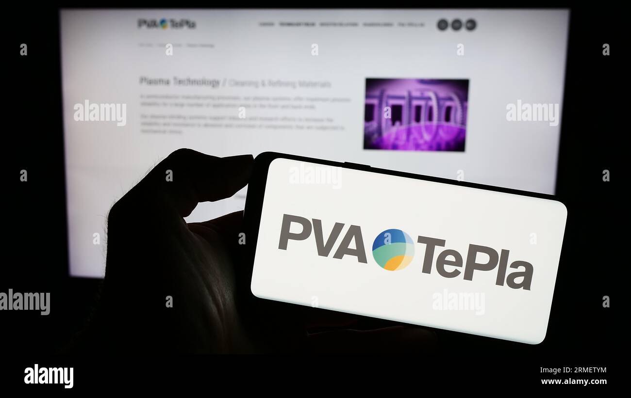 Person holding mobile phone with logo of German technology company PVA ...