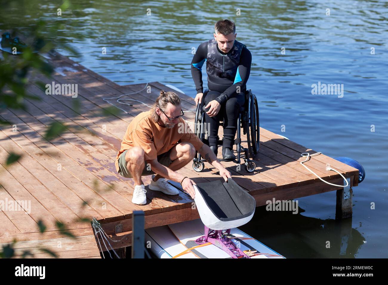Portrait of senior water sports instructor preparing adaptive ...