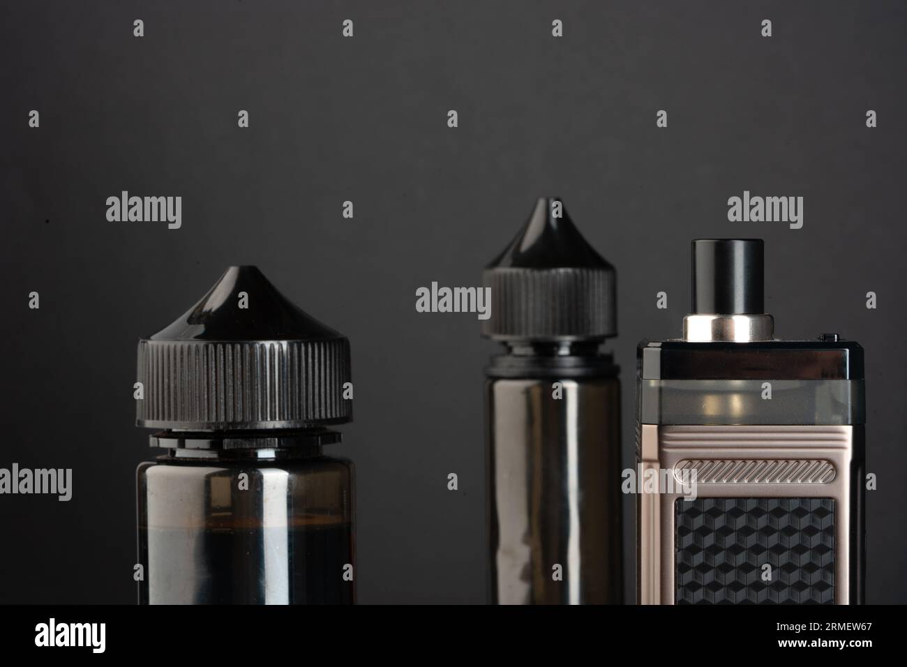 Vape and vape liquid bottles against black background Stock Photo - Alamy