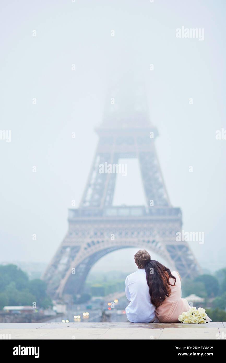 Beautiful romantic couple in love with bunch of white roses sitting ...