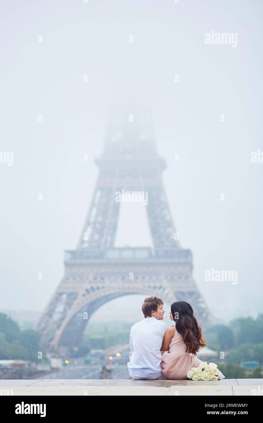 Beautiful romantic couple in love with bunch of white roses sitting ...