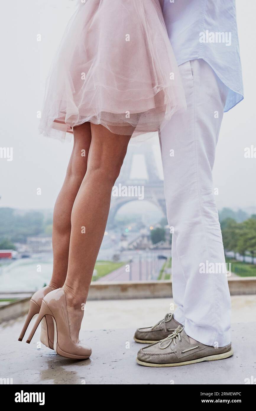 Couple having a date, kissing or hugging in front of the Eiffel tower ...