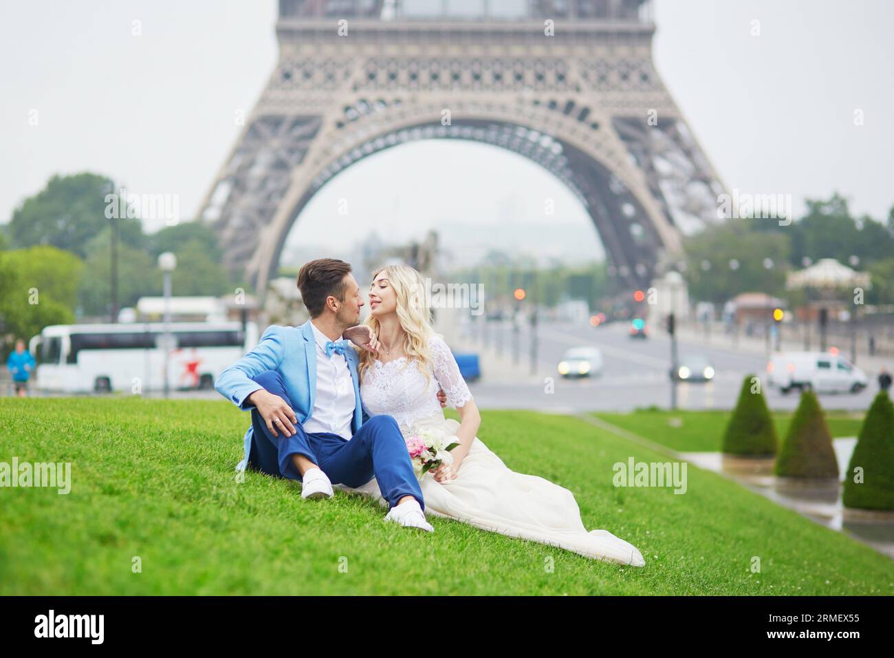 Just married couple near the Eiffel tower on their wedding day. Bride ...