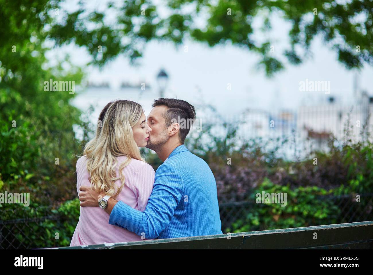 Couple kissing on park bench hi-res stock photography and images - Alamy