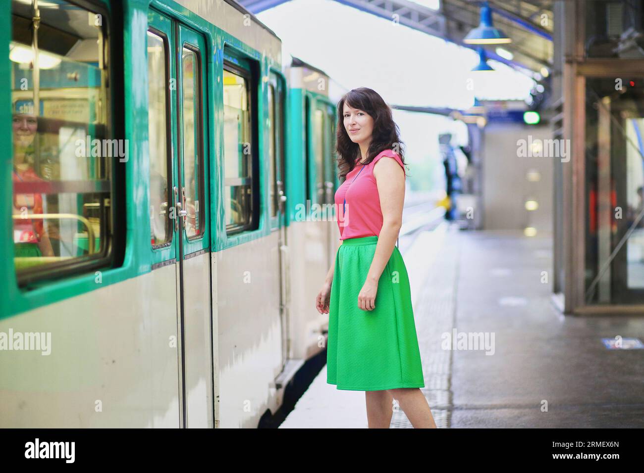 Young woman in Paris boarding a Parisian underground train. Local French commuter going to work ...