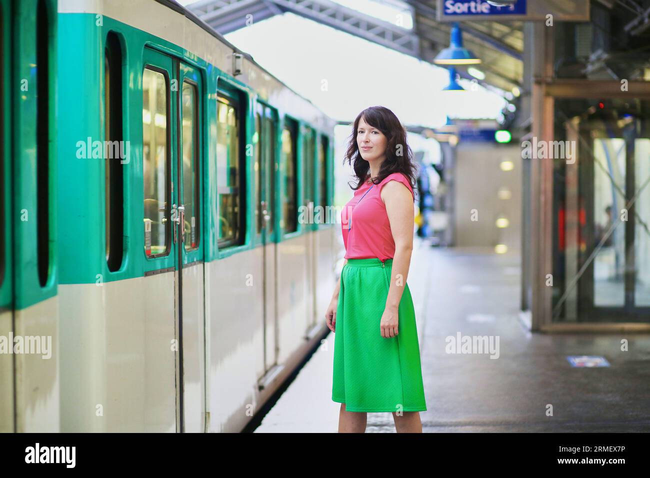 Young woman in Paris boarding a Parisian underground train. Local French commuter going to work ...
