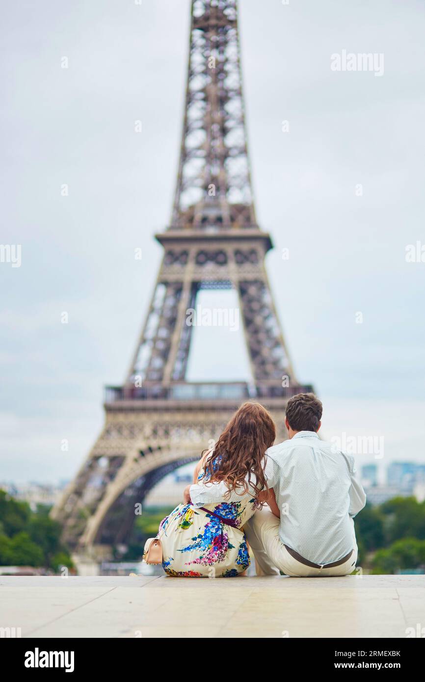 Romantic loving couple having a date near the Eiffel tower. Tourists on ...