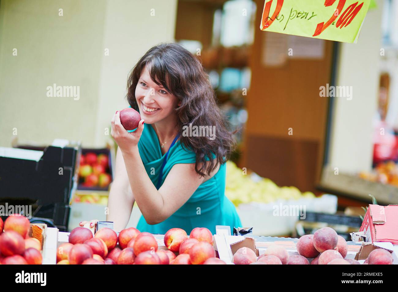 Beautiful French woman choosing ripe organic peaches on a Parisian ...
