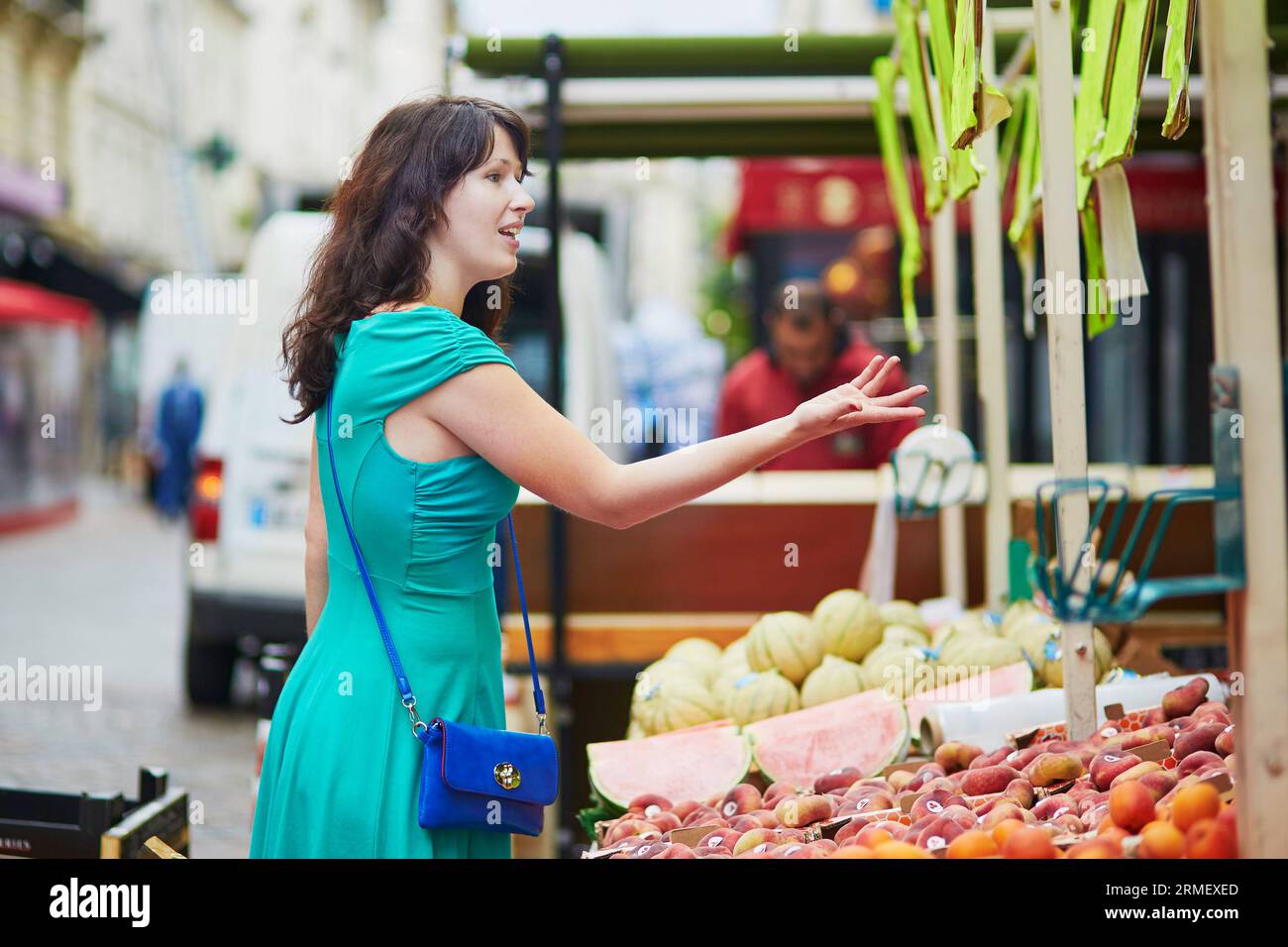 Beautiful French woman negotiating the price on a Parisian local market ...