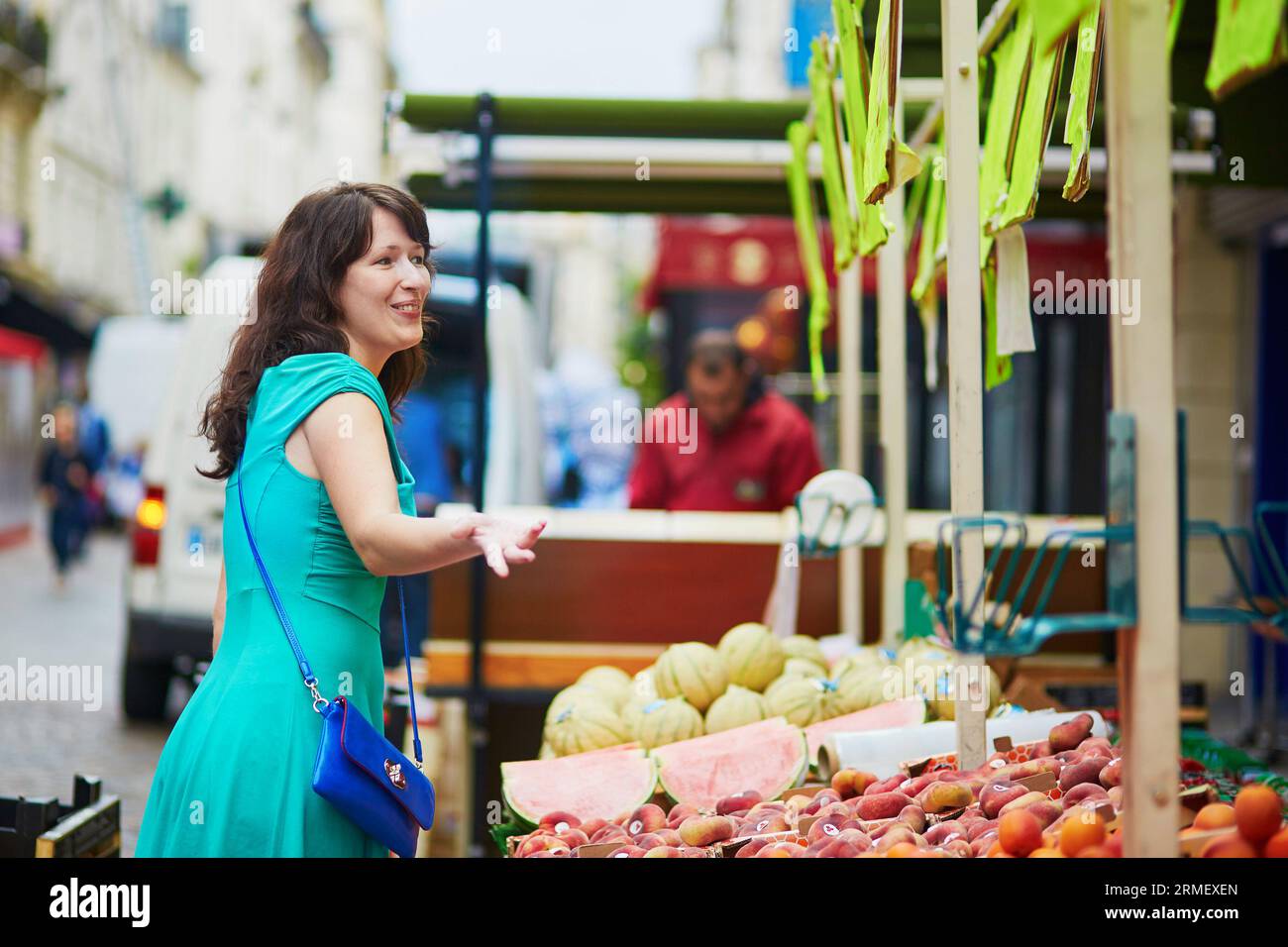 Beautiful French woman negotiating the price on a Parisian local market ...