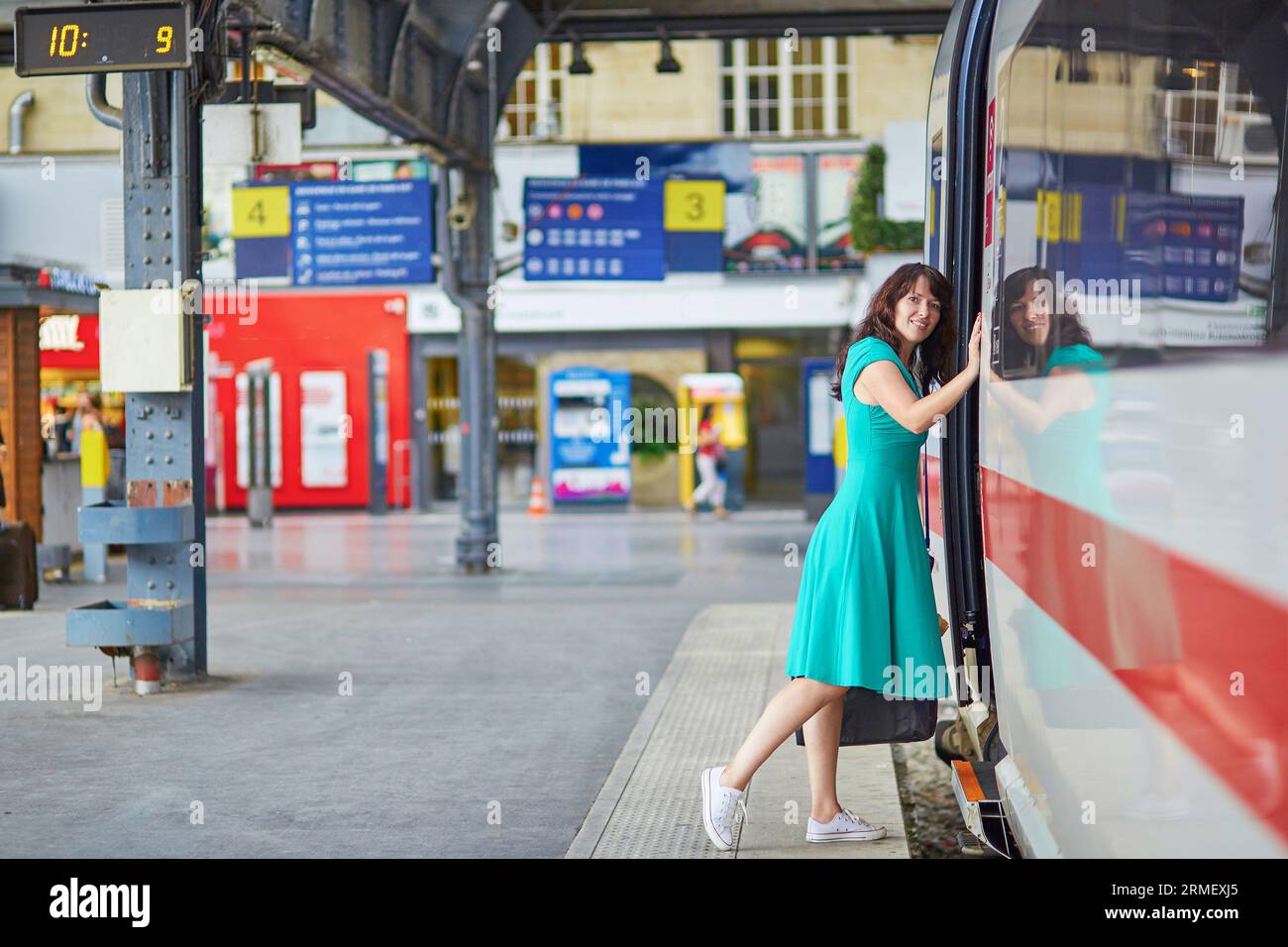 Young woman in Paris boarding a train on railway station. Local French ...