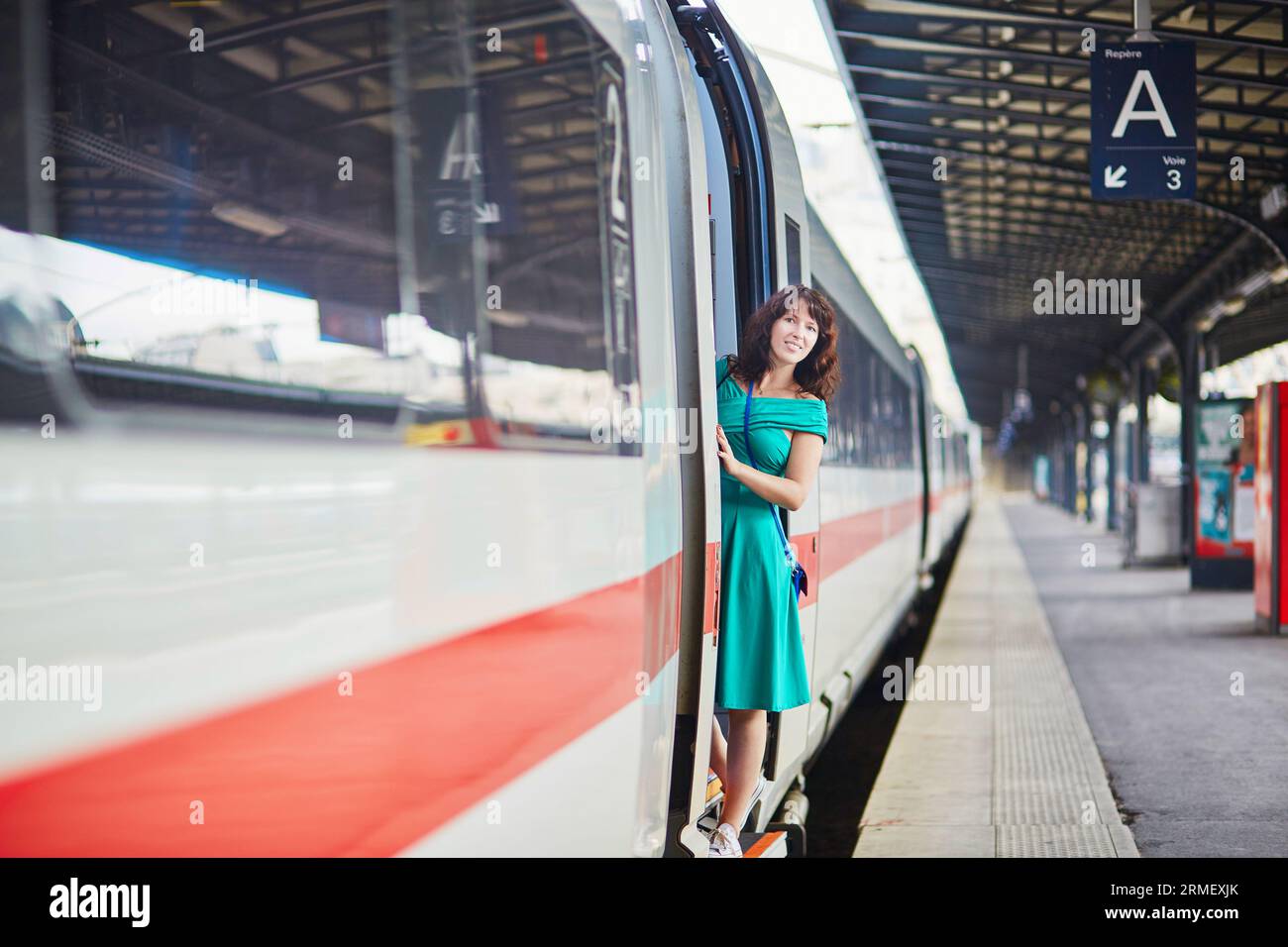 Young woman in Paris boarding a train on railway station. Local French ...