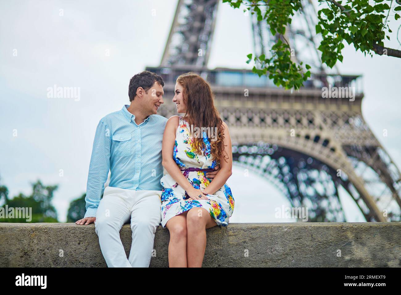 Happy romantic couple sitting near the Eiffel tower in Paris, Tourists ...