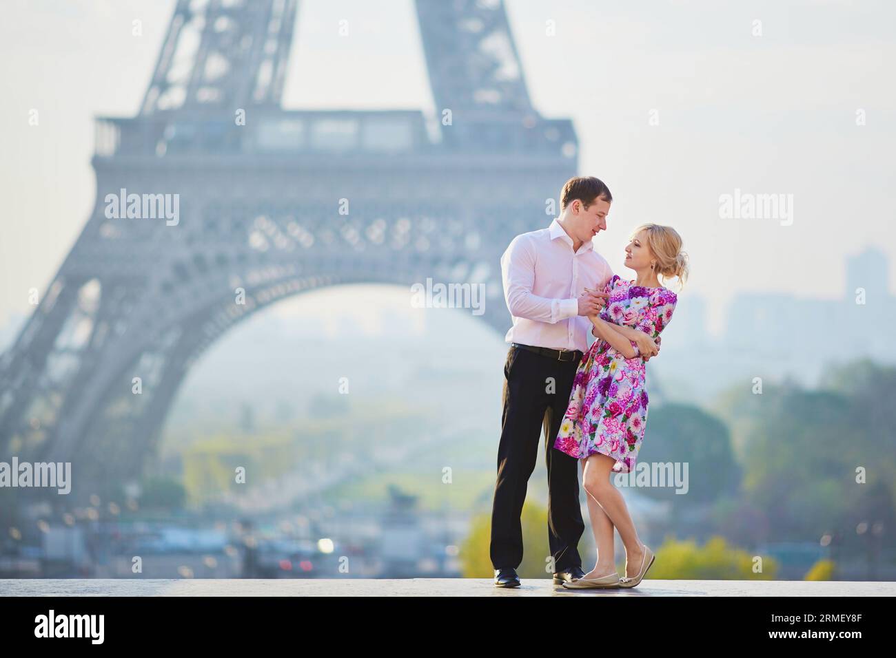 Beautiful romantic couple hugging in front of the Eiffel tower in Paris ...