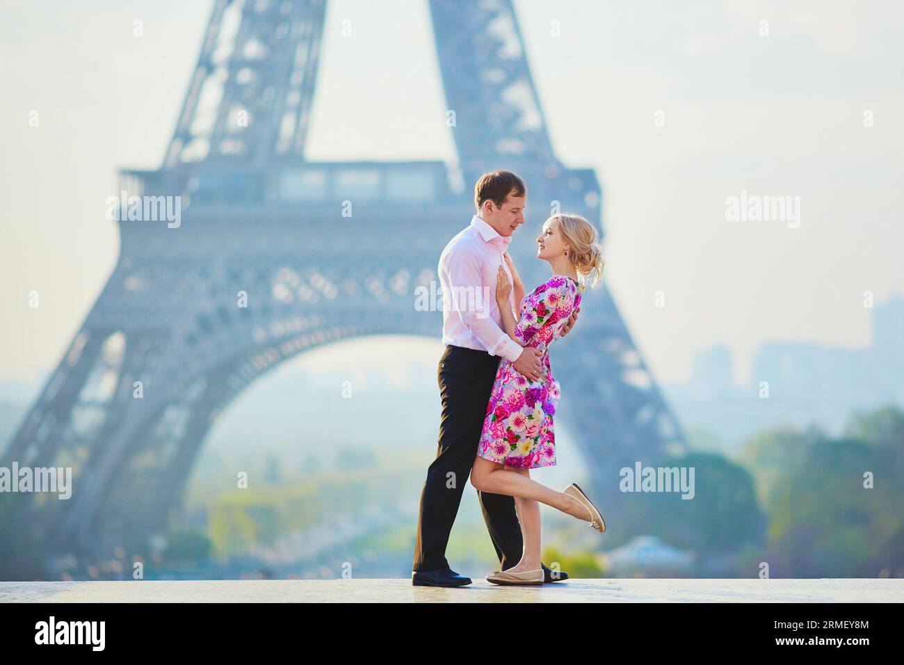 Beautiful romantic couple hugging in front of the Eiffel tower in Paris ...