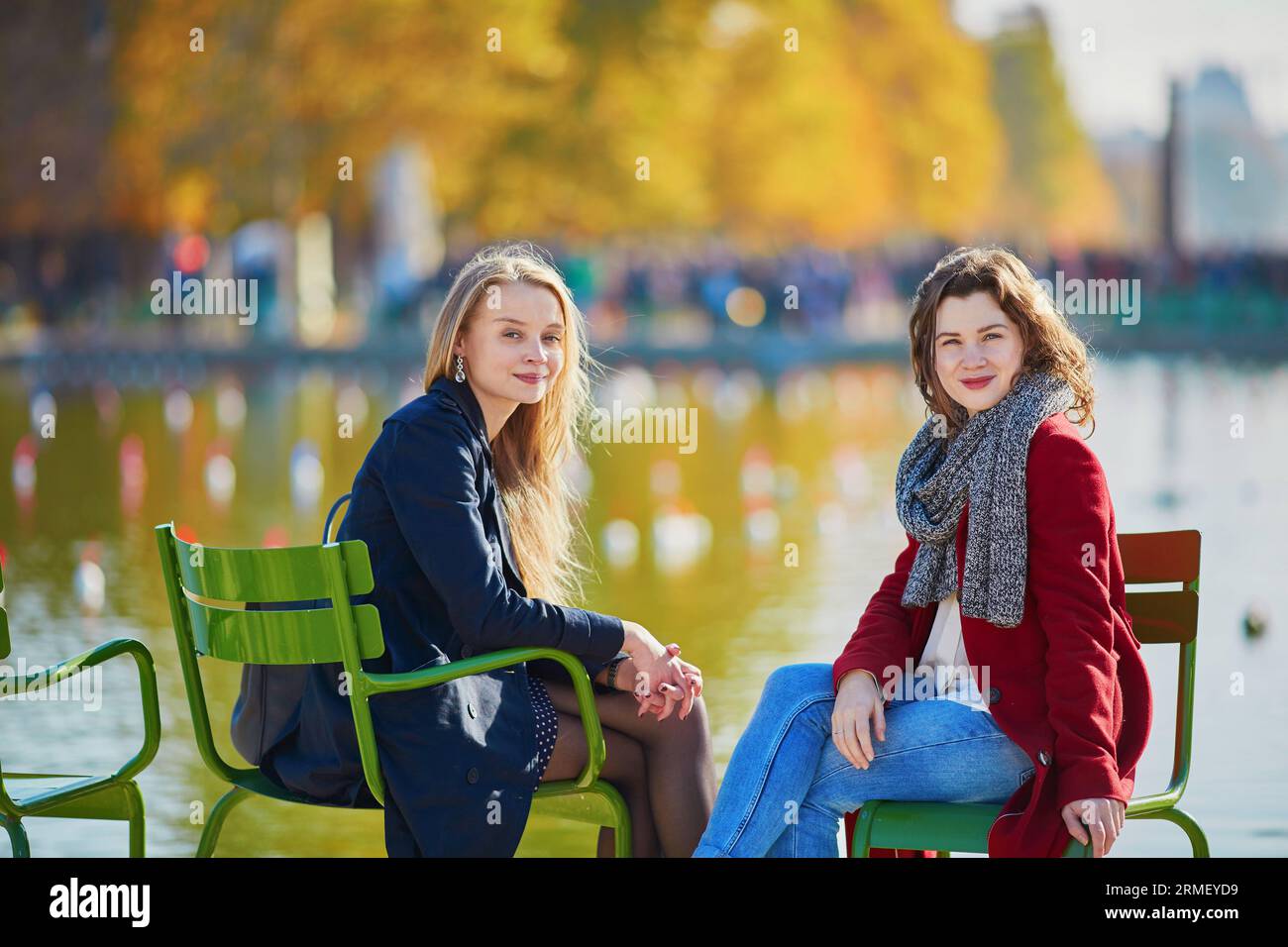 Two young girls in Tuileries garden of Paris on sunny fall day ...