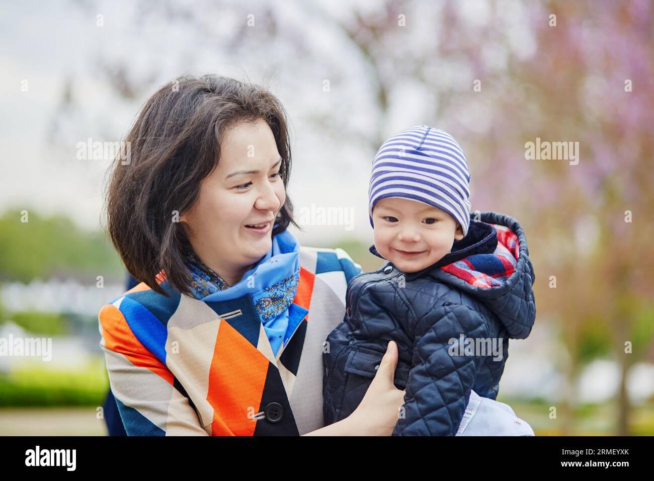 Happy family of two in Paris on a spring day with purple jacarandas in ...
