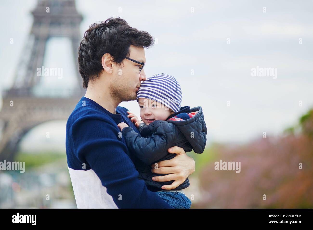 Father holding his little son near the Eiffel tower in Paris. Happy ...