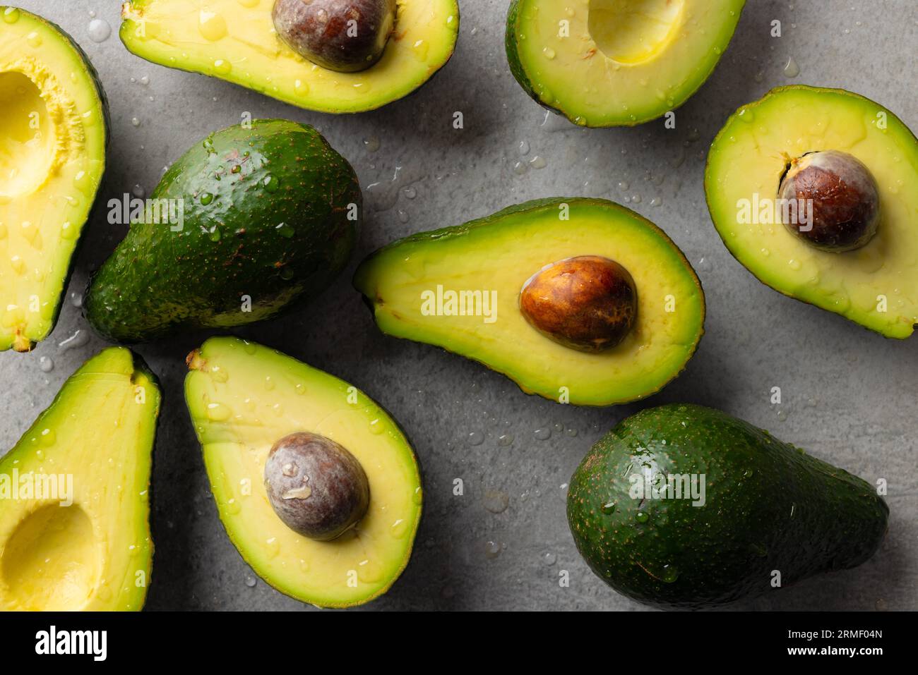 Micro close up of avocados with water drops and copy space on grey ...