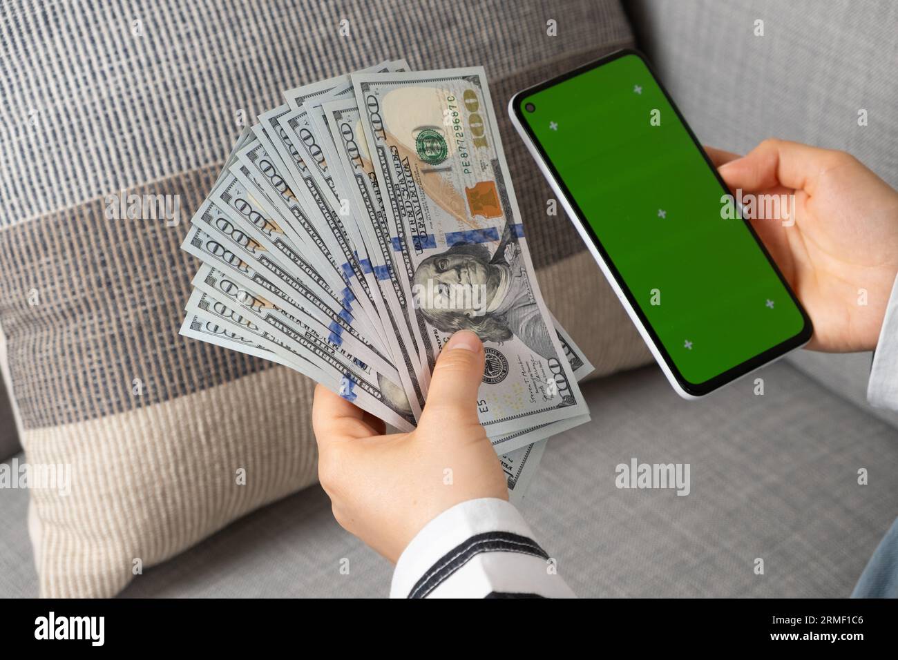A smartphone with a green chrome key screen and a lot of hundred-dollar ...
