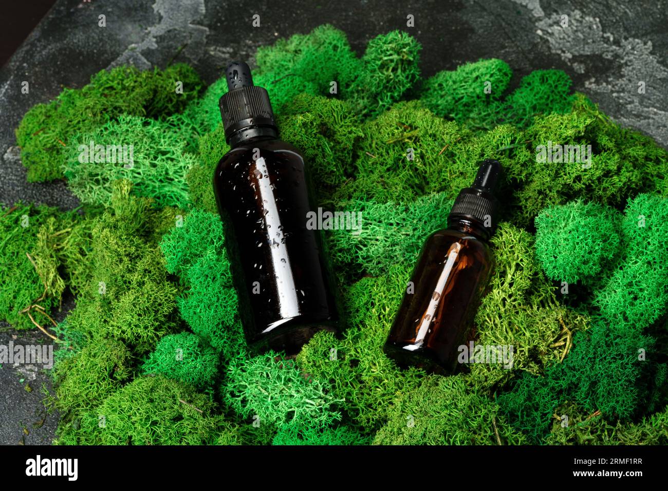 Vape smoking liquid bottles on moss background Stock Photo - Alamy