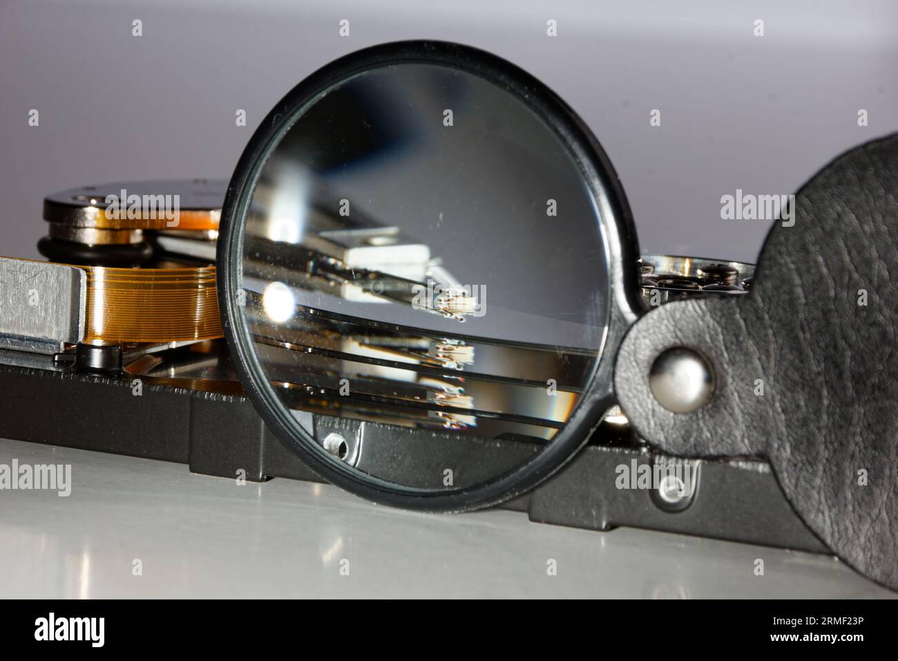 hard drive and magnifying glass, representing the process of searching ...