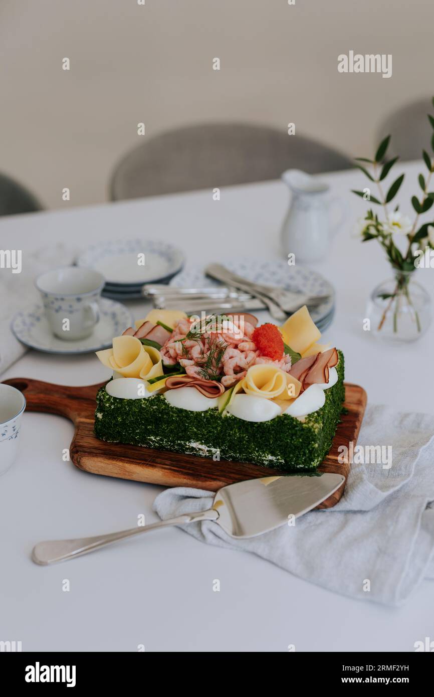 Swedish sandwich cake with shrimps, cheese, ham and eggs on wooden ...
