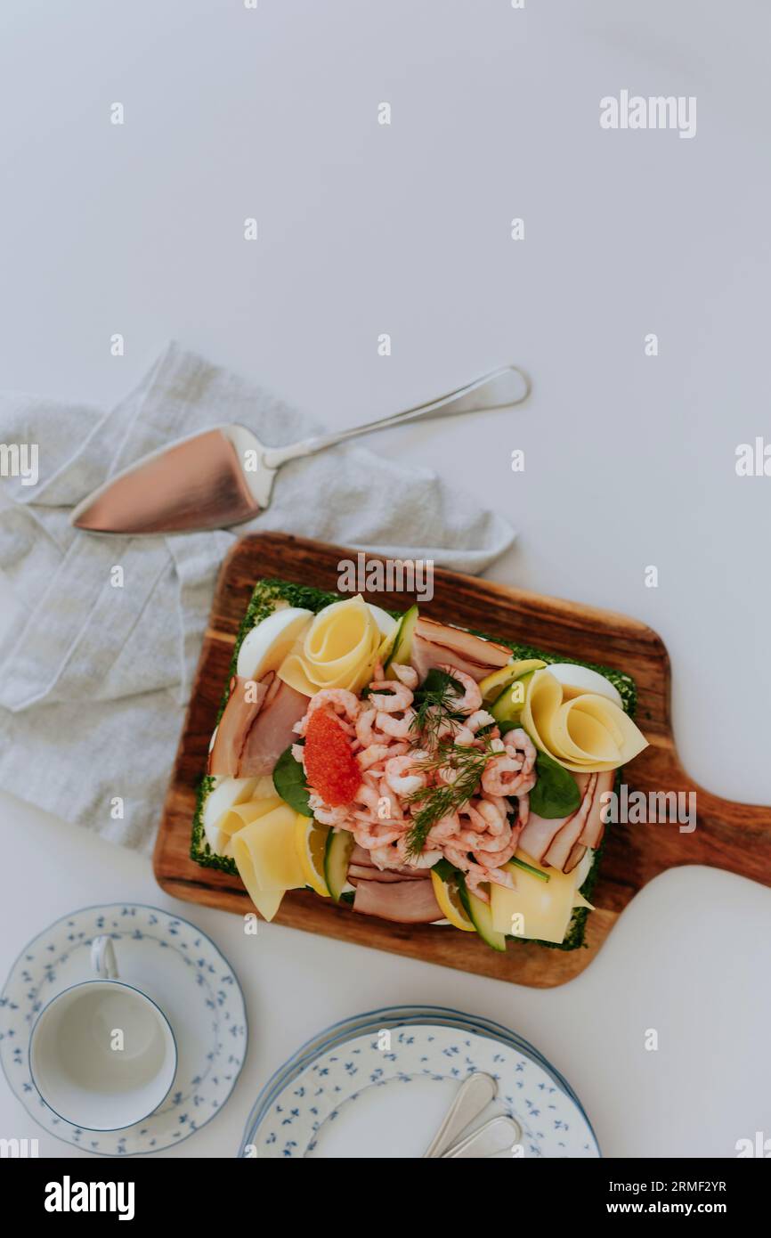 Swedish sandwich cake with shrimps, cheese, ham and eggs on wooden ...