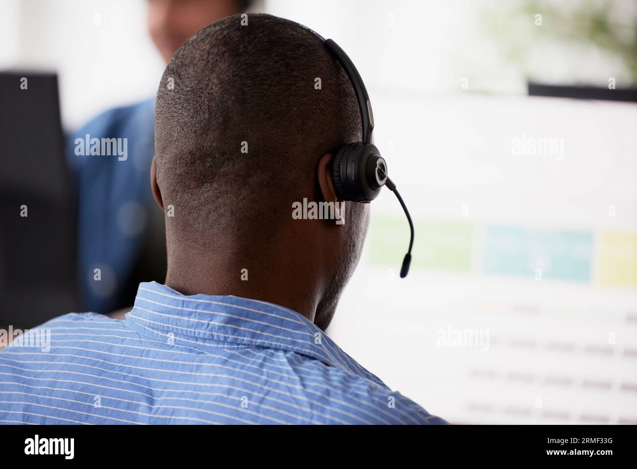 Rear view of man using headset while sitting in office Stock Photo - Alamy