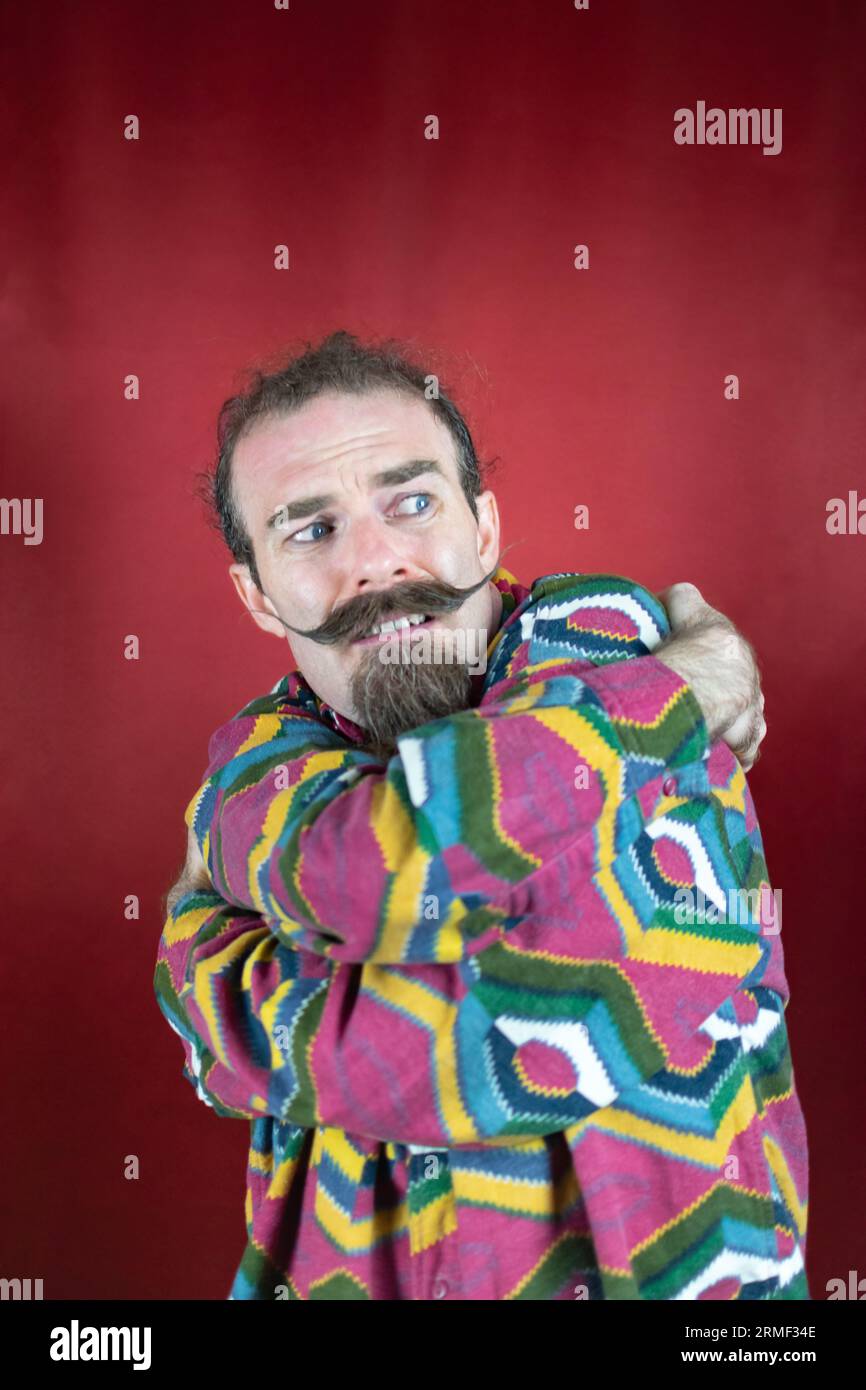 Hipster terrified man with mustache and hugging himself with fear ...