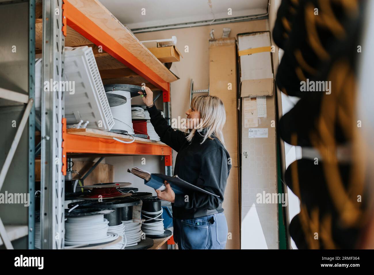 Female worker checking equipment inventory Stock Photo - Alamy