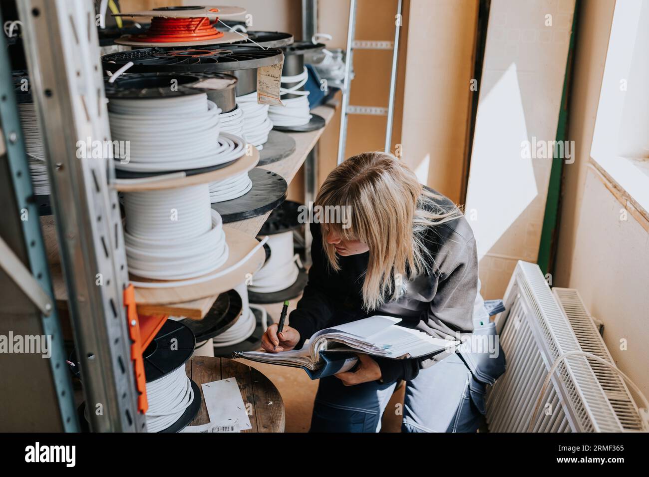 Female worker checking equipment inventory Stock Photo - Alamy