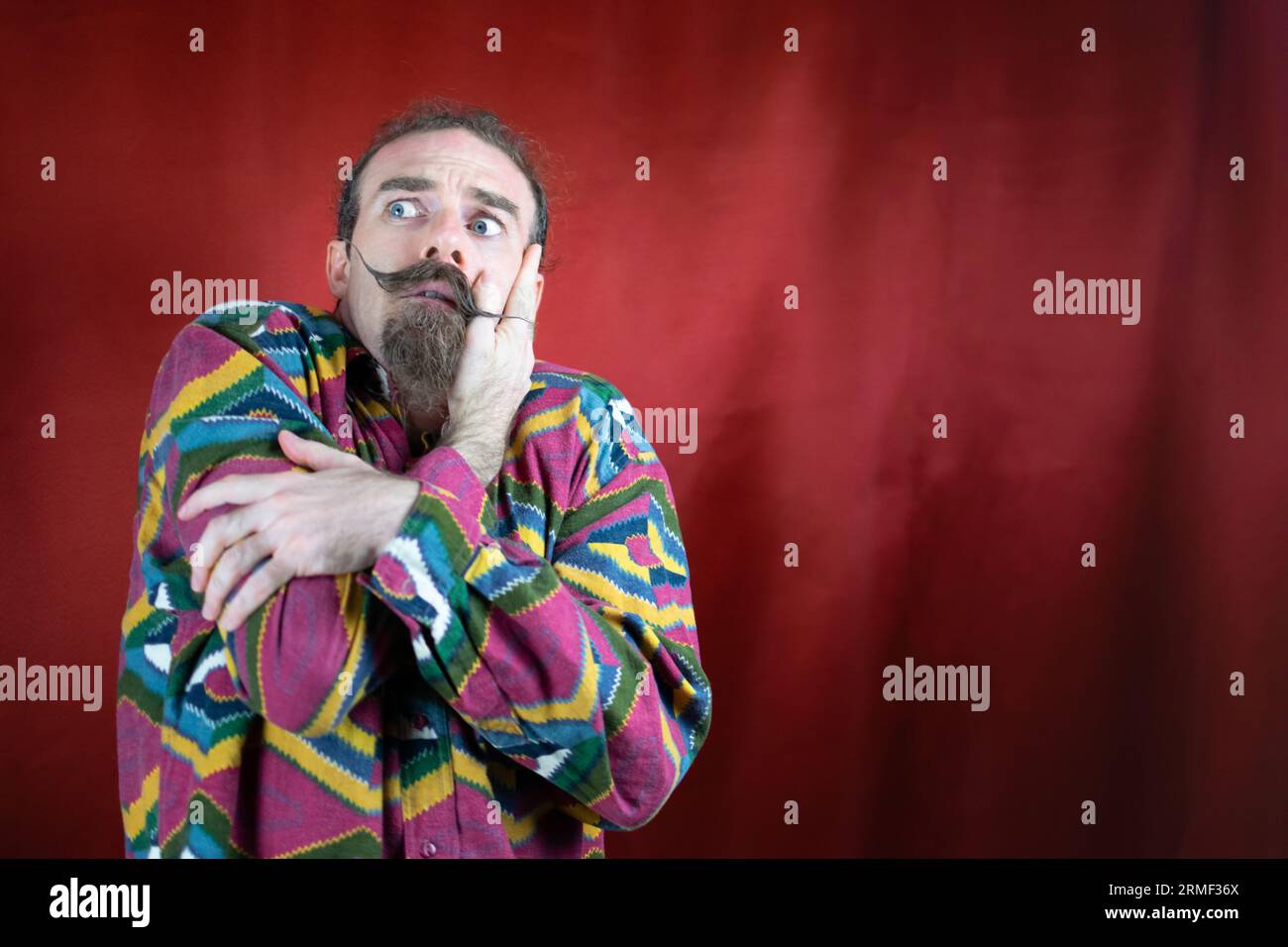 Hipster terrified man touching his face and hugging himself with fear ...