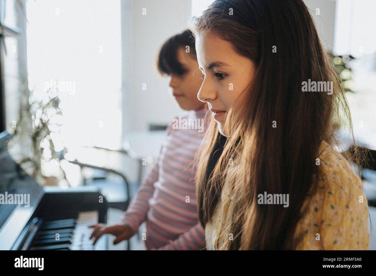 Sisters bonding over playing piano together Stock Photo - Alamy
