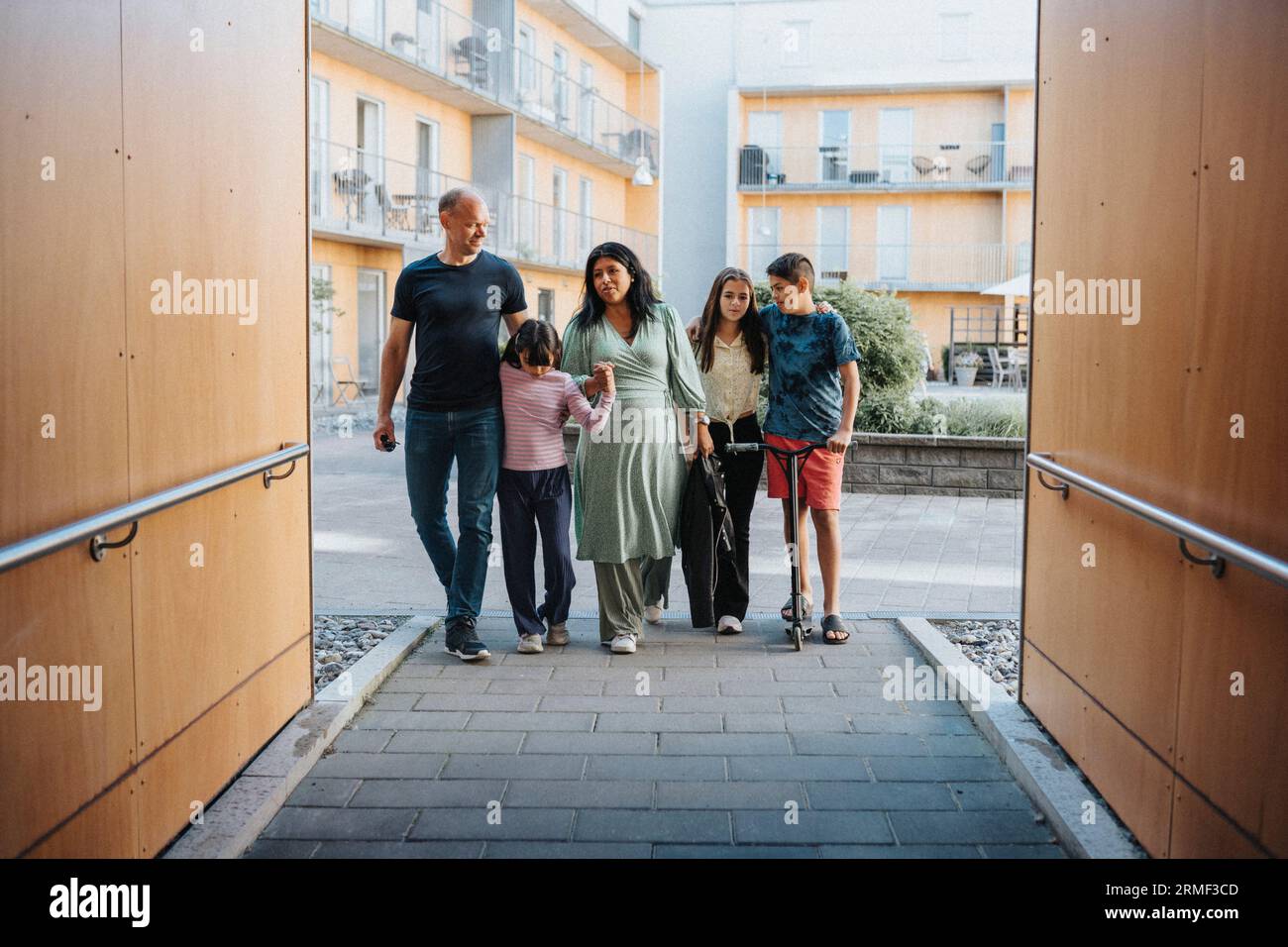 Family standing in courtyard of residential neighborhood Stock Photo ...