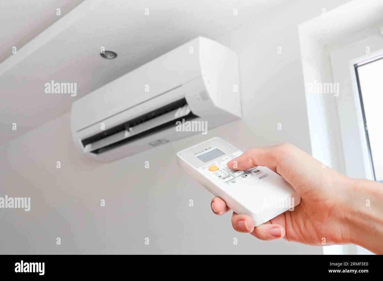 Air conditioner temperature adjustment with remote controller in room ...